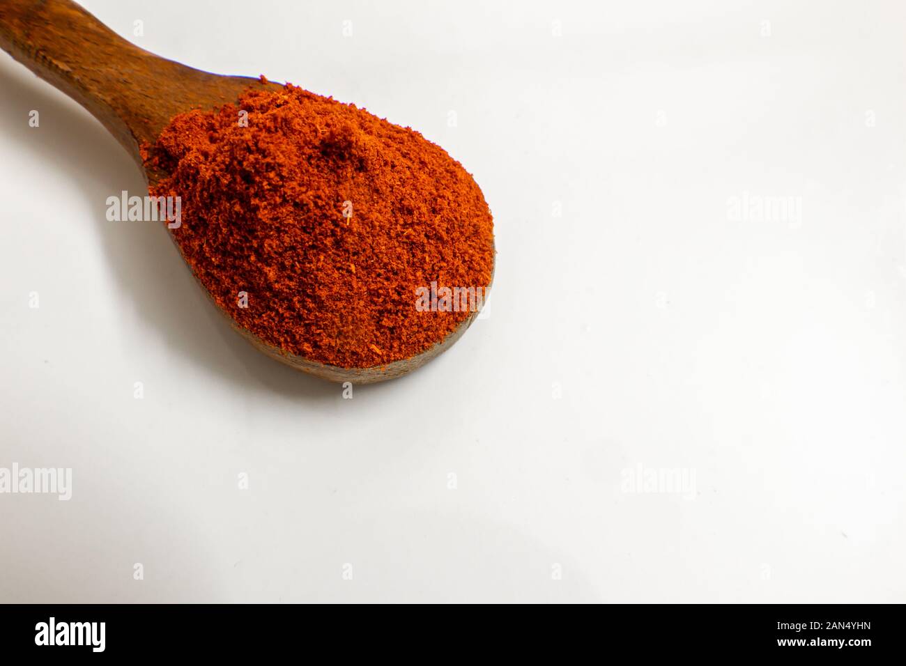 Spoon full of red chilli pepper powder over white background. Mirchi ...