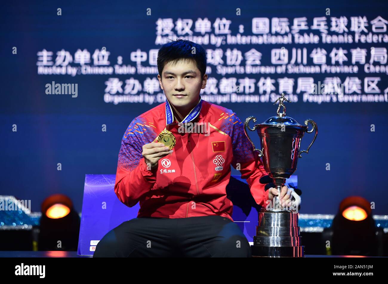 Fan Zhendong of China shows the medal and cup after winning the first ...