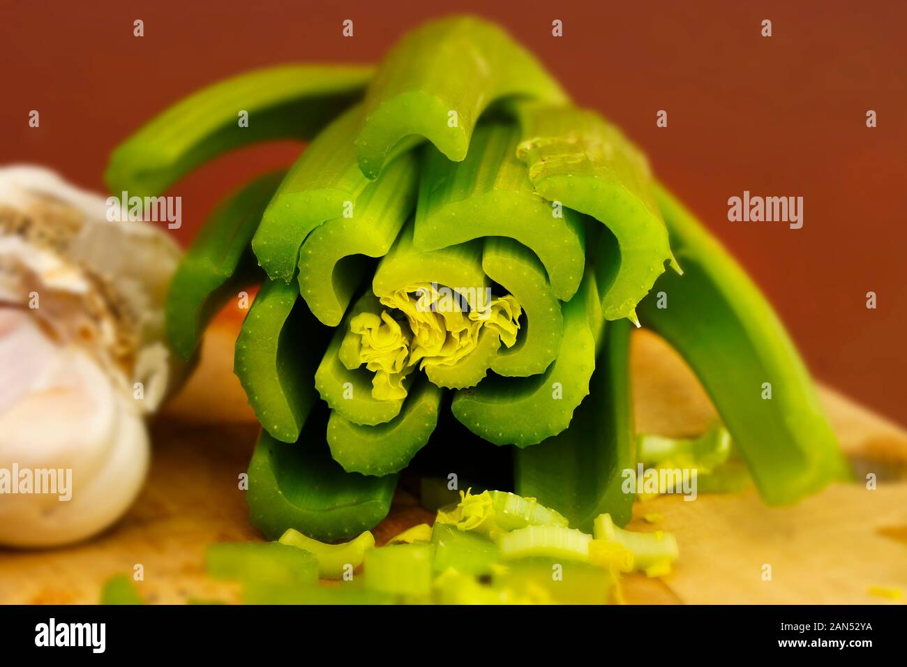 Macro horizontal photograph of garlish cloves and cut celery side by ...