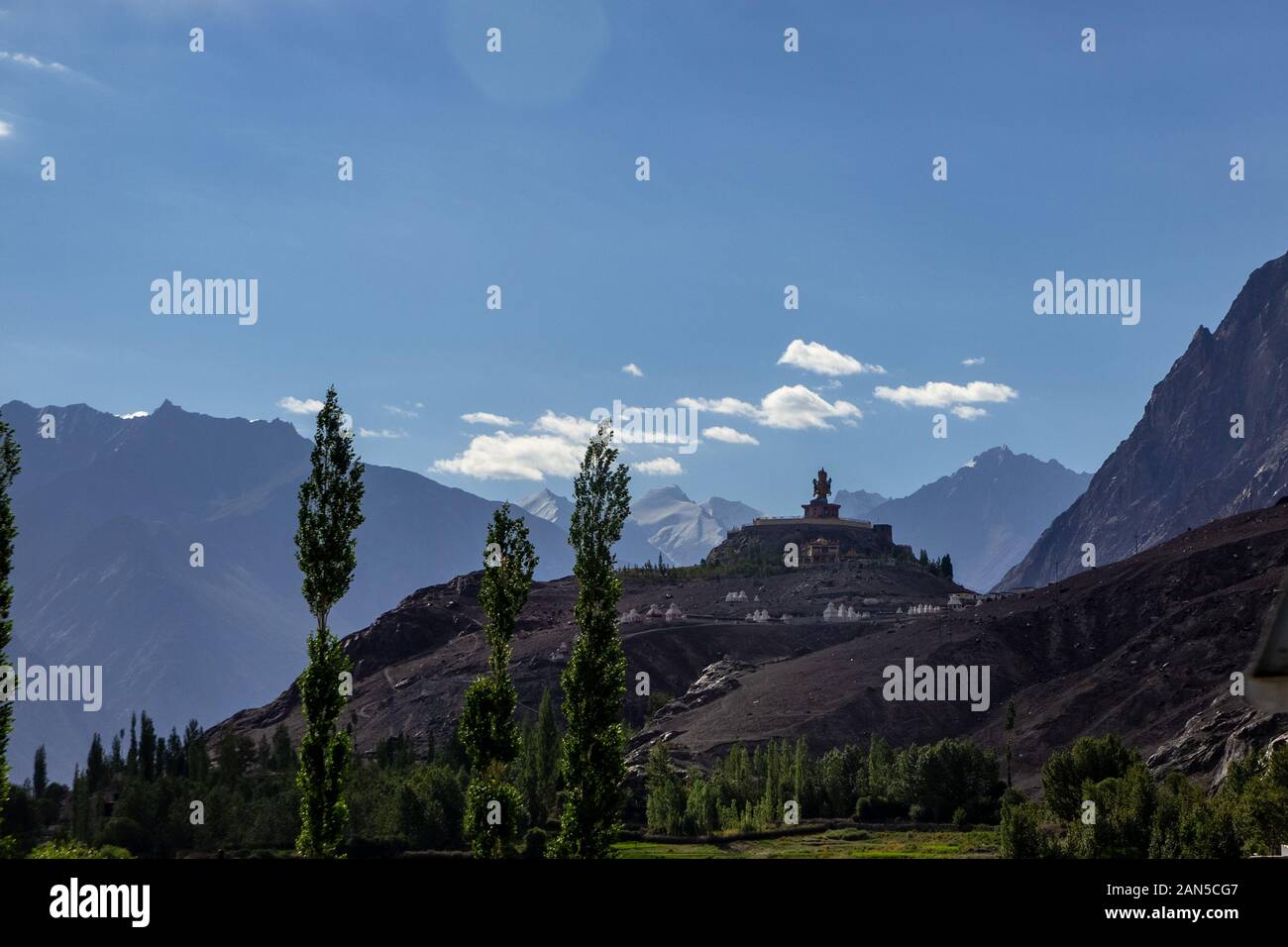 green vegetation with mountain top and distant impression of an idol ...