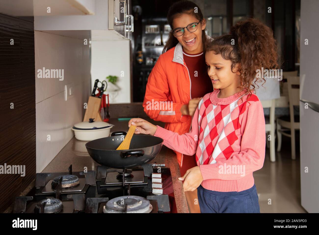 Sisters cooking together in the kitchen at home. (Children Stock Photo ...