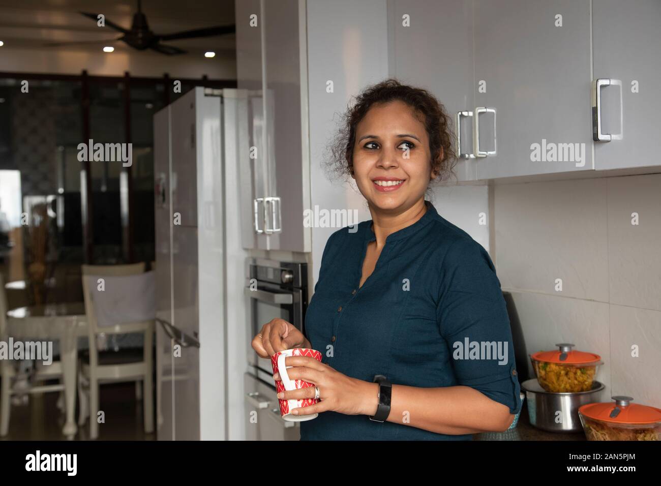 Young woman standing in the kitchen and beating coffee in the cup Stock ...