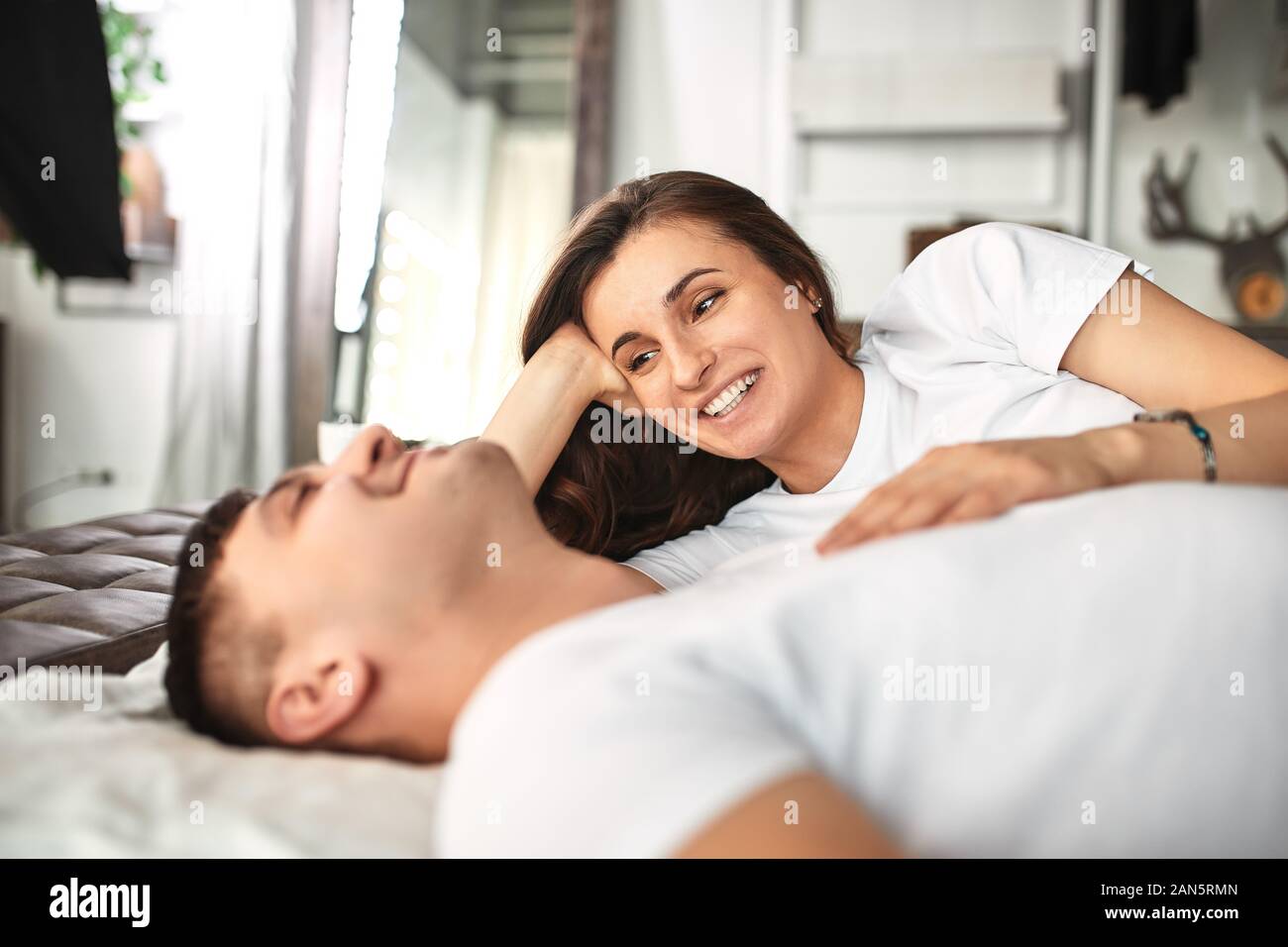 A young married couple awaiting a baby. Beautiful couple lying in the ...