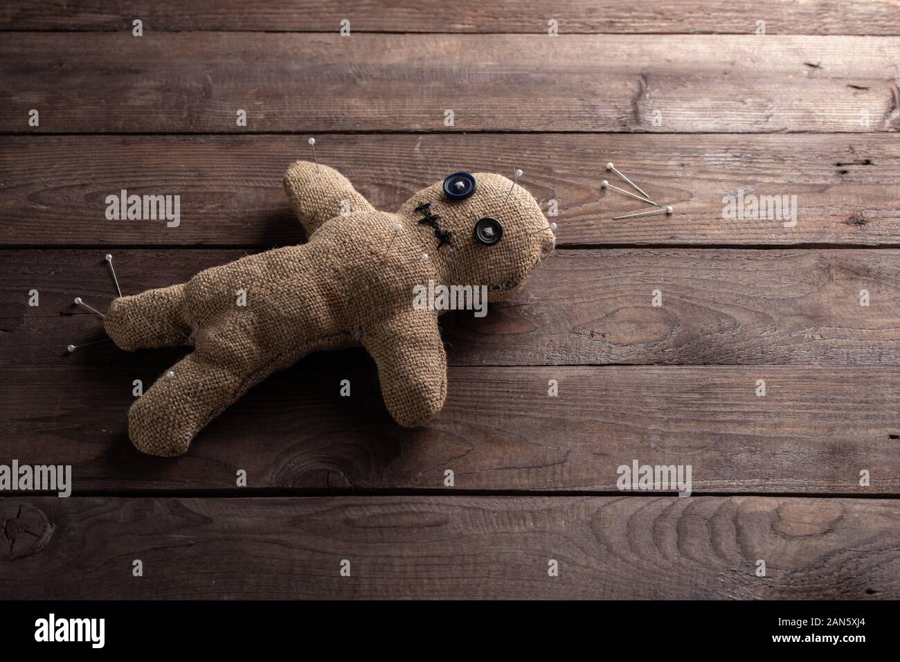 Voodoo doll on a wooden background with dramatic lighting. The concept ...