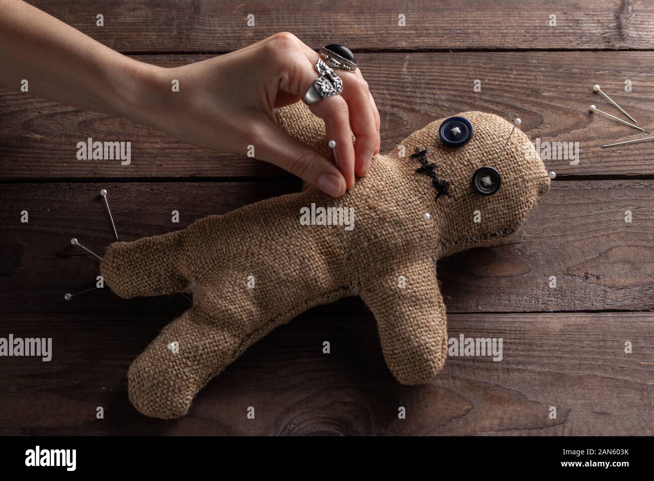 Voodoo doll on a wooden background with dramatic lighting. The concept ...