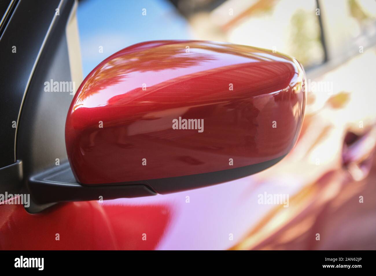 Red car with side rear view mirror on a modern car side mirror front ...