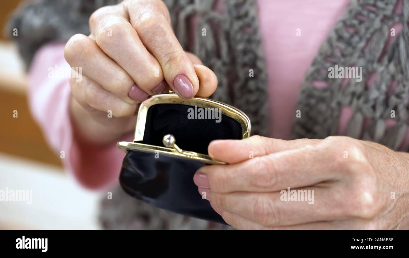 Female pensioner holding empty wallet, retirement poverty, high utility ...