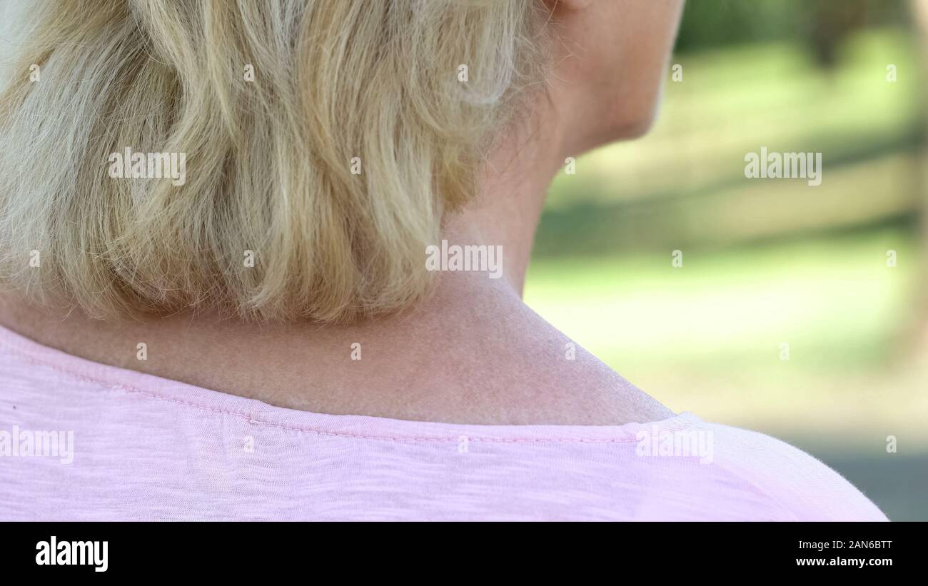 Mature woman sitting on bench and looking in distance, recreation for ...