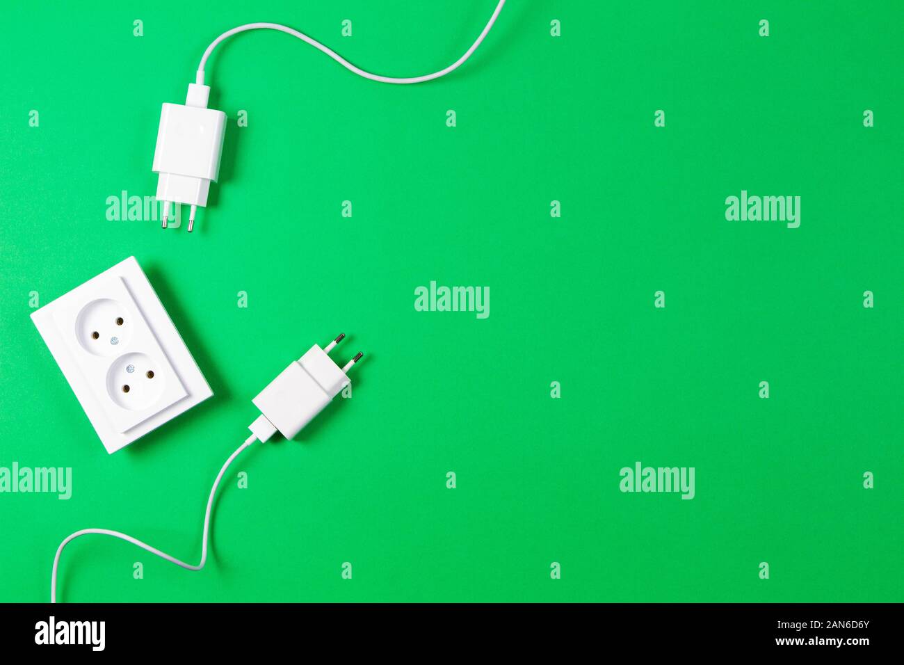 White electrical power sockets and power plug on light green background ...