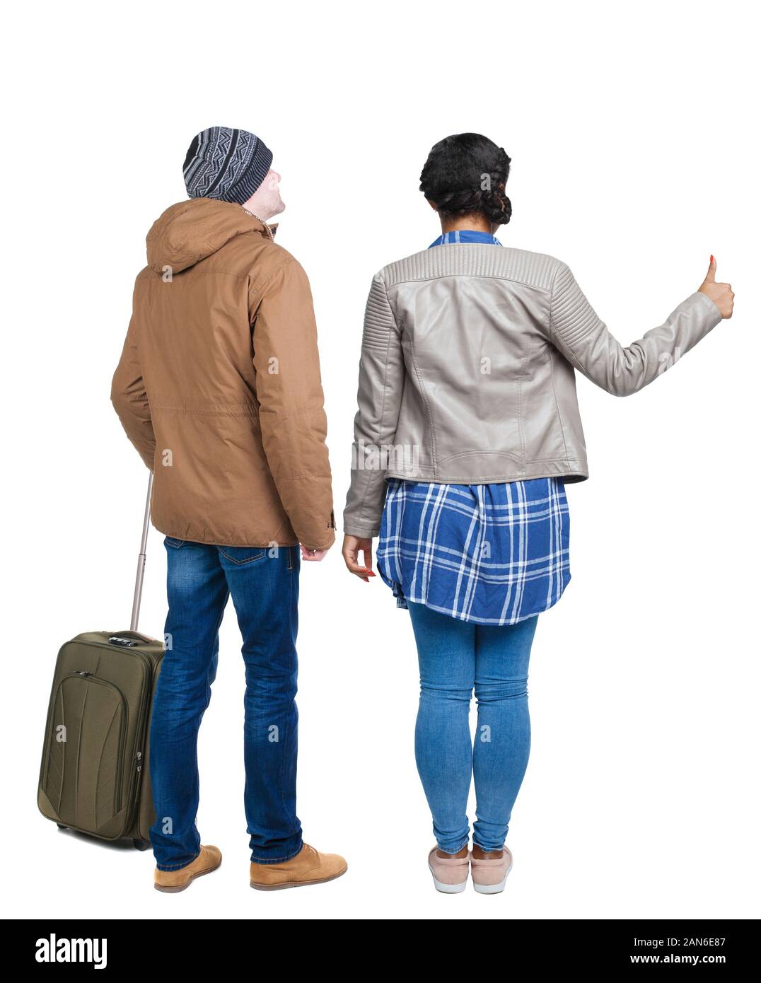 young couple in winter jacket traveling with suitcas. Back view. Rear ...