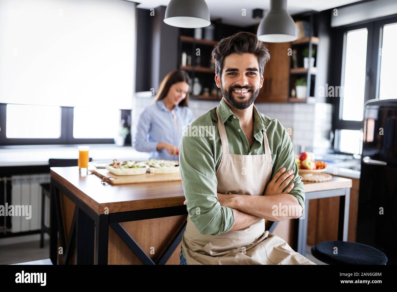 Happy young friends loving couple chefs on the kitchen cooking Stock ...