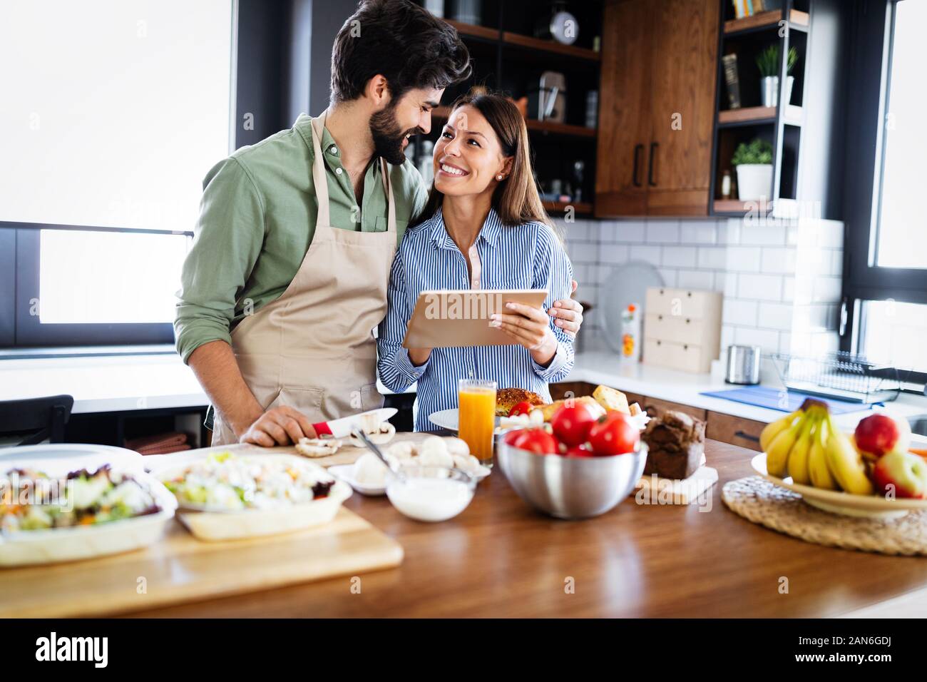 Beautiful couple in the kitchen while cooking Stock Photo - Alamy