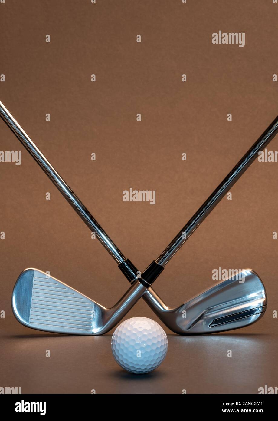 Two crossed golf clubs and golf ball in the middle, vertical ...
