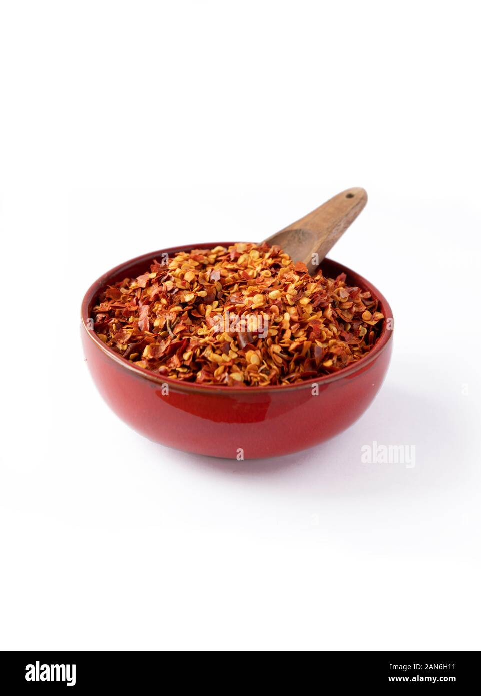 season organic Hot chilli flakes in a red colored bowl with spoon ...