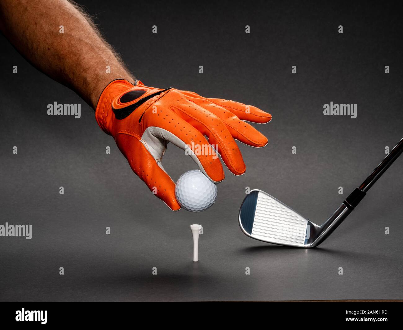 Man's hand positioning a golf ball Stock Photo - Alamy