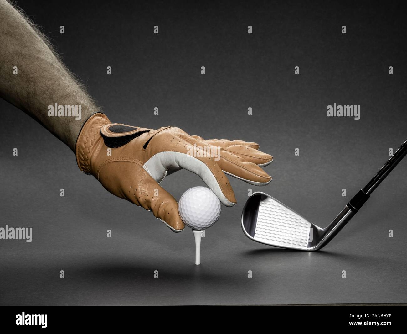 Man's hand positioning a golf ball Stock Photo - Alamy