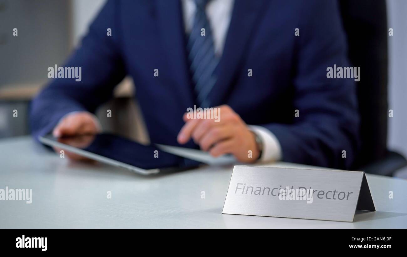 Busy financial director of corporation using tablet pc, planning ...
