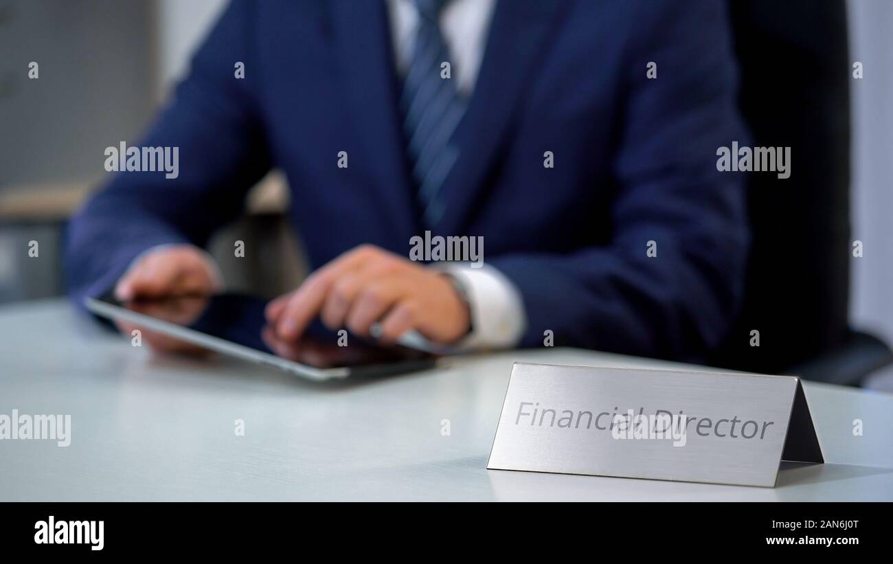 Serious financial director of corporation working on tablet pc, budget ...