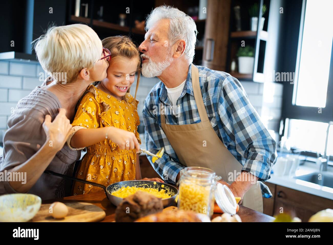Smiling grandparents having breakfast with their granddaughter Stock ...