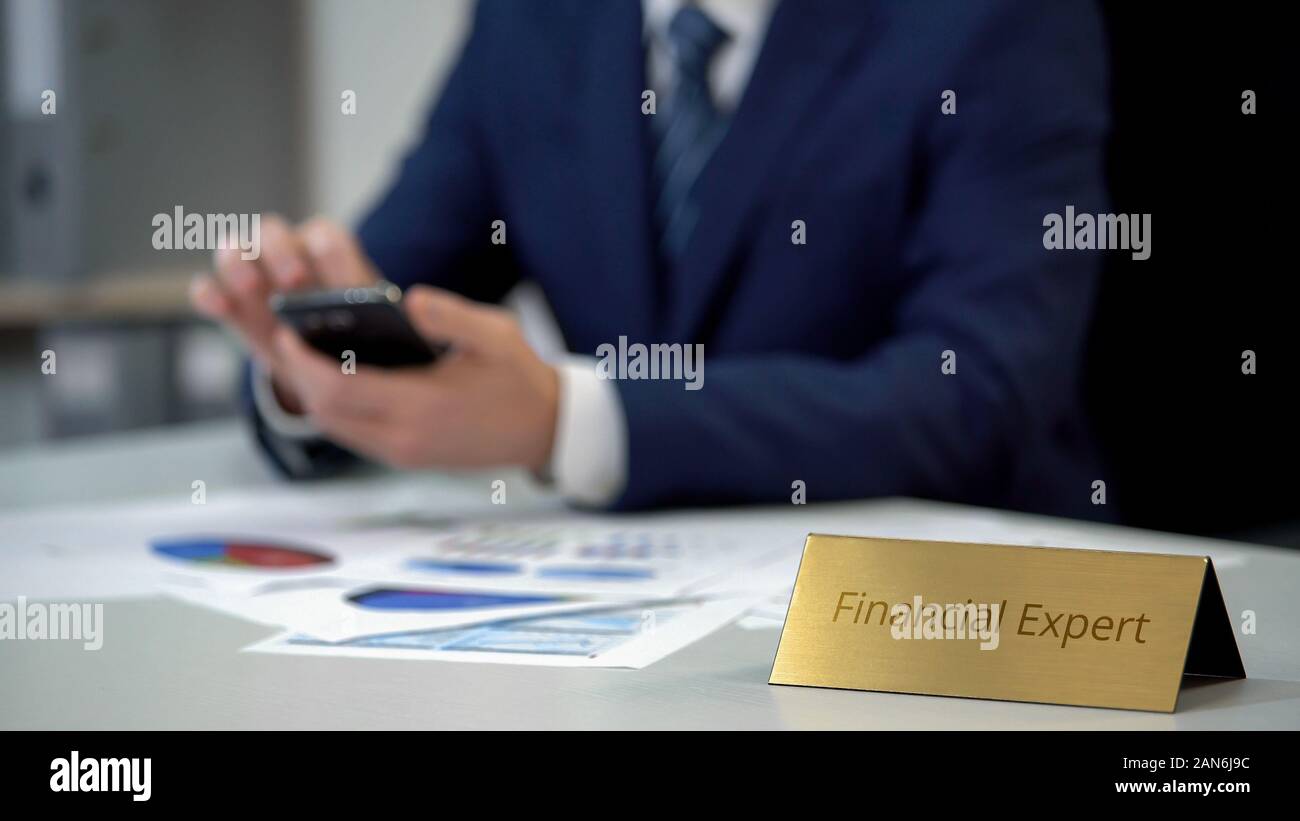 Male financial expert using smartphone, viewing business documents with ...
