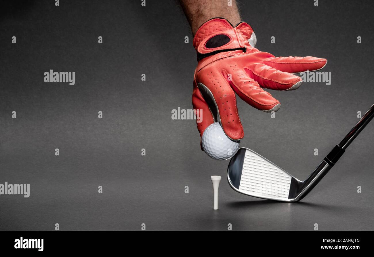 Man's hand positioning a golf ball Stock Photo - Alamy