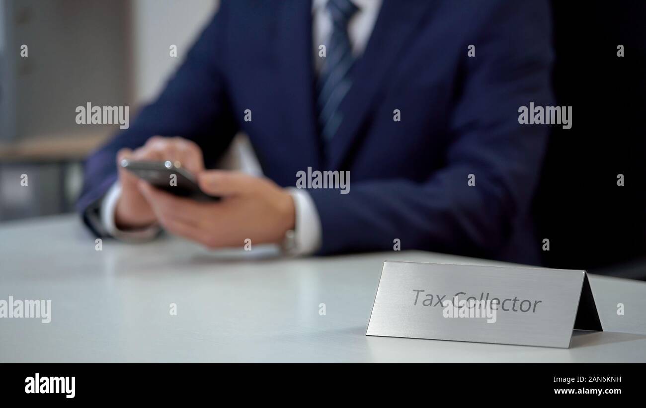 Male tax collector using smartphone, texting messages to debtors ...
