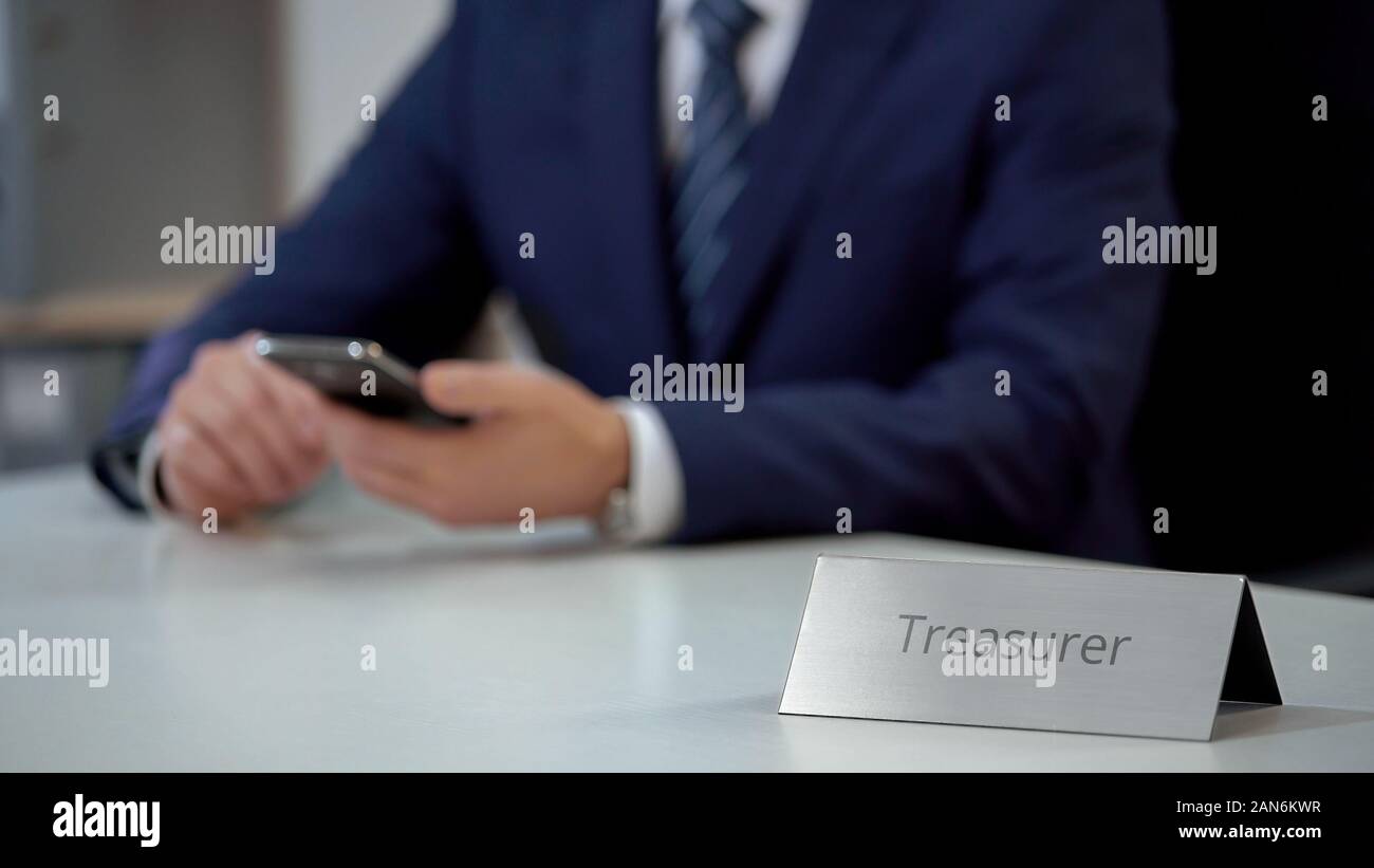 Corporate treasurer using smartphone, planning costs and revenues of ...