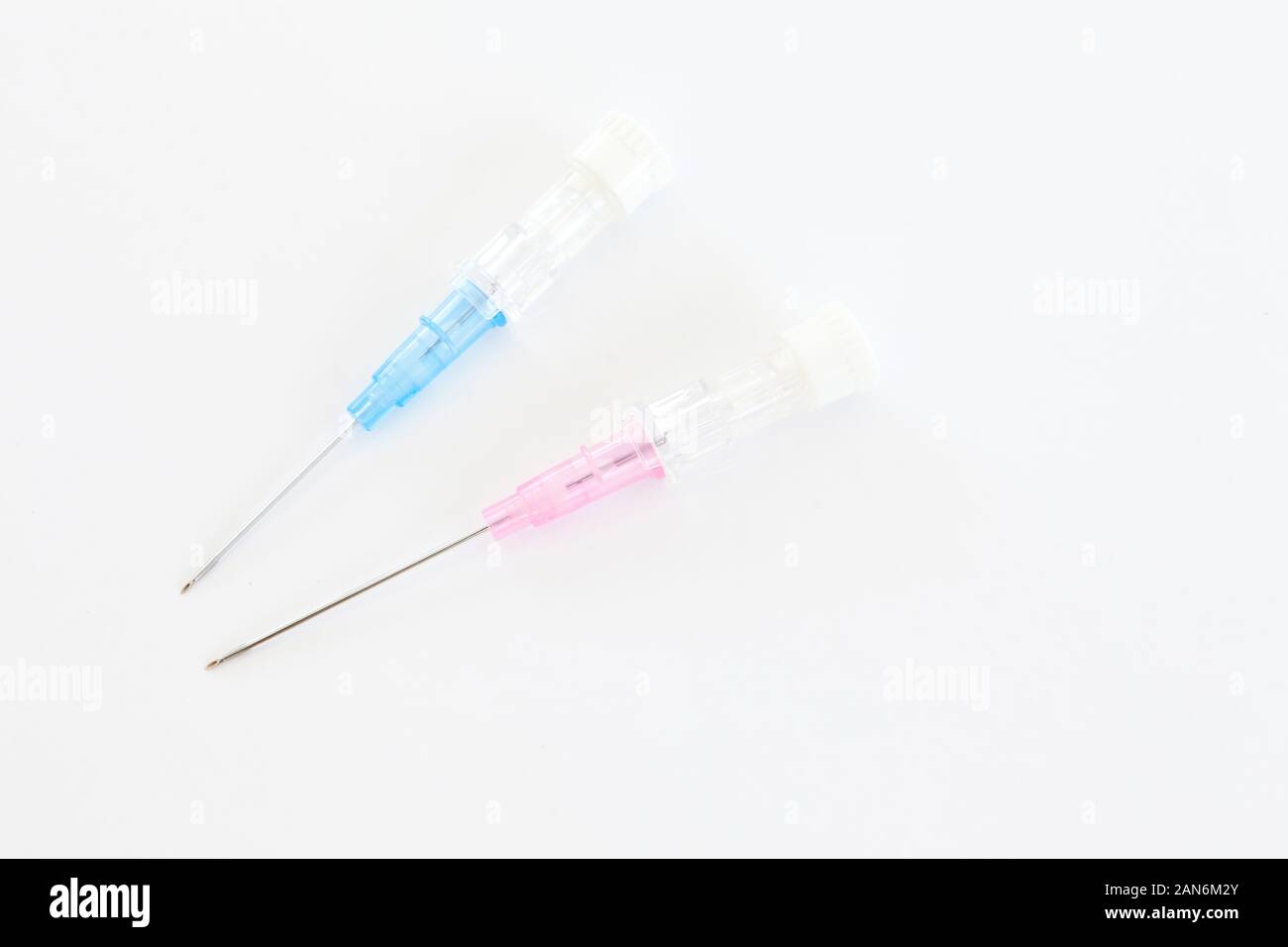 Pink and blue medical needles isolated in white Stock Photo - Alamy