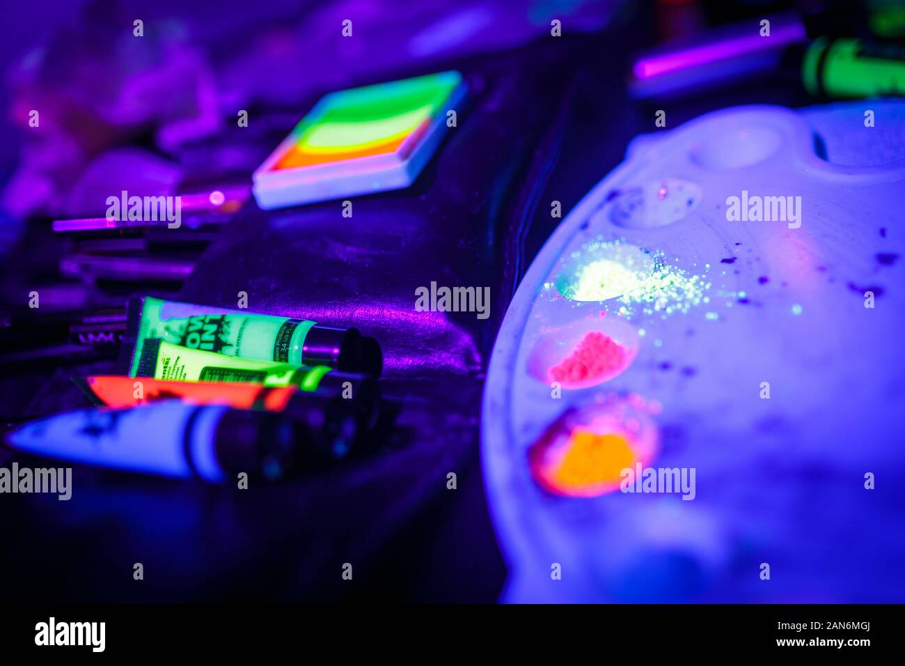 Multicolored UV fluorescent powder and paints on a palette Stock Photo ...