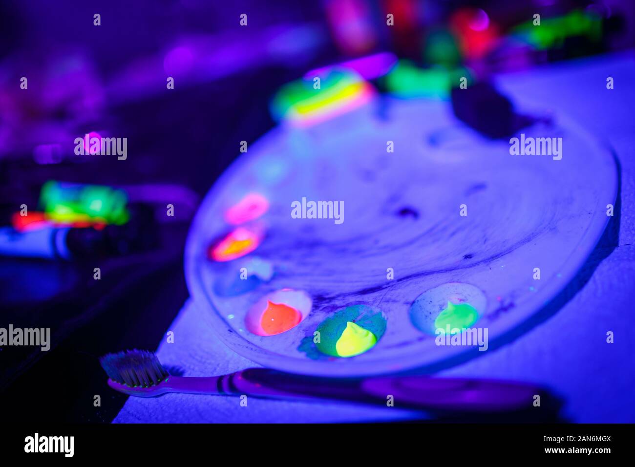 Multicolored UV fluorescent powder and paints on a palette Stock Photo ...