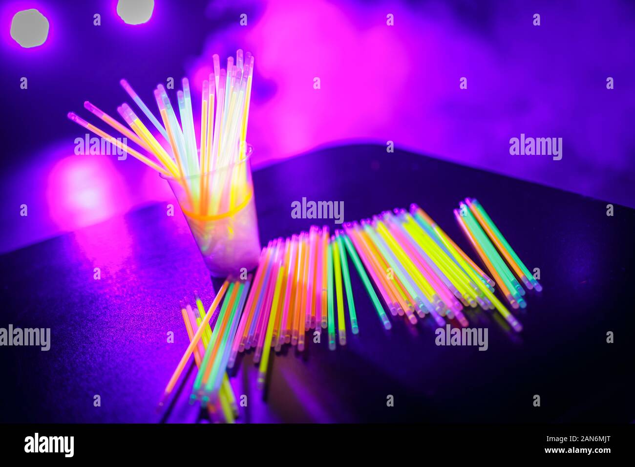Multicolored UV fluorescent sticks in a glass at a techno party Stock ...