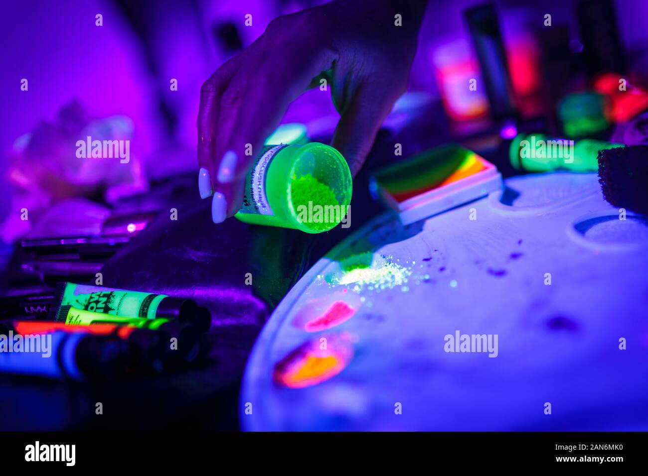 Multicolored UV fluorescent powder and paints on a palette Stock Photo ...