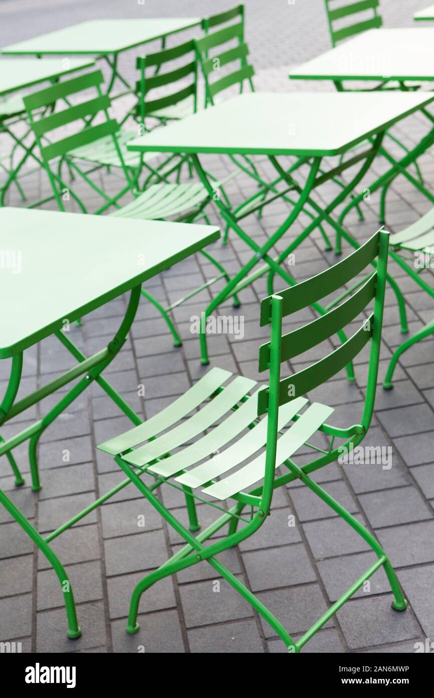 Green metal chairs and tables outside Stock Photo - Alamy
