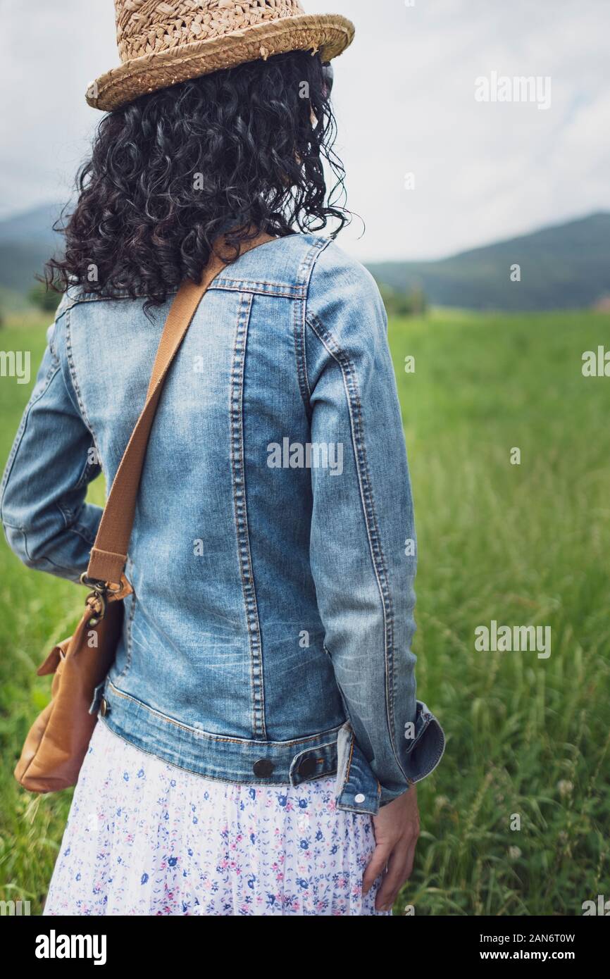 Woman from behind standing and looking at the countryside Stock Photo ...