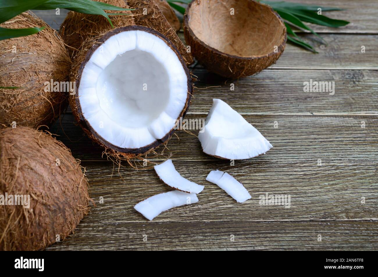 Coconut. Whole coconut, shell, coconut flakes and green leaves on a ...