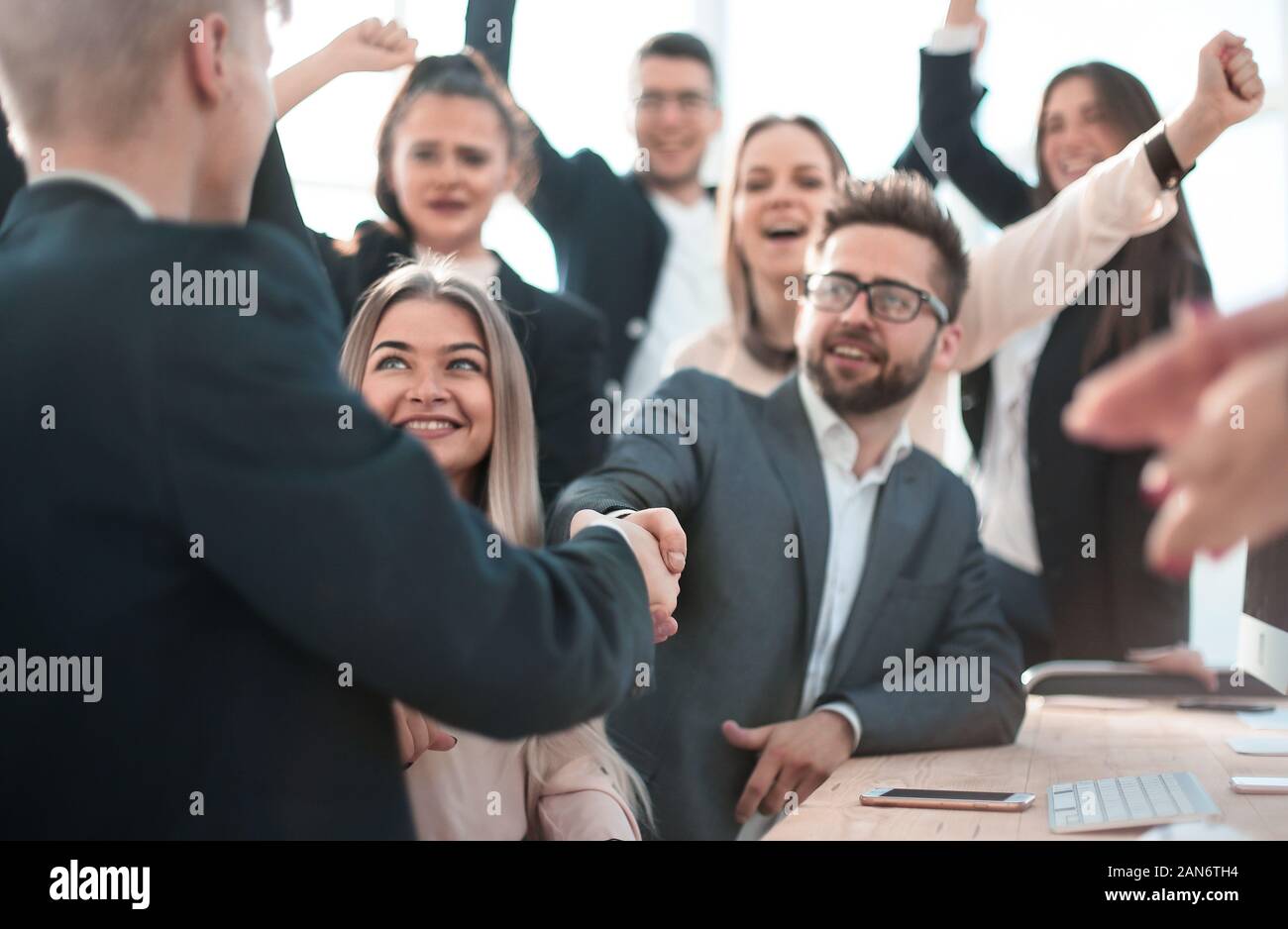 Manager congratulating a young employee in the workplace Stock Photo ...