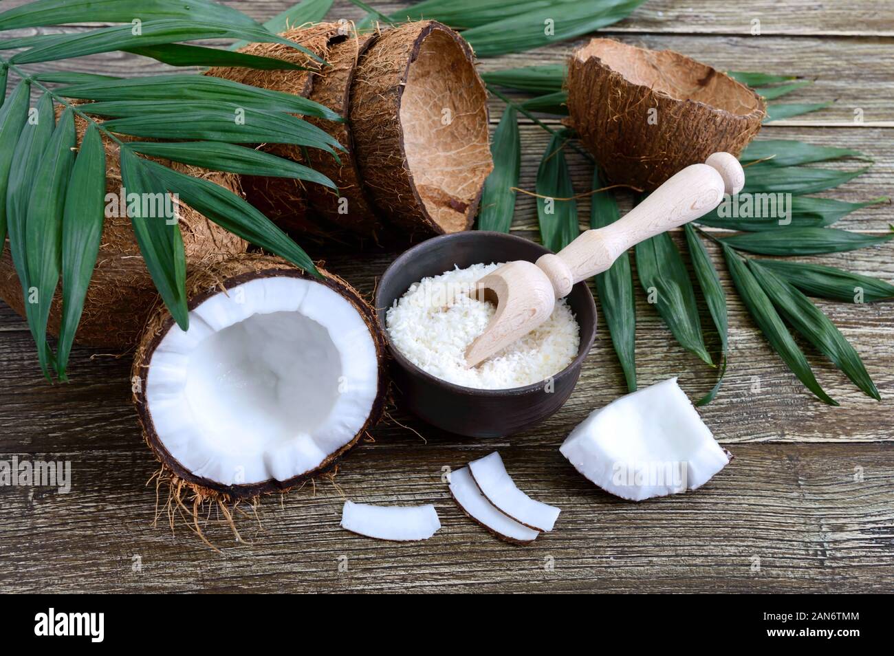 Coconut. Whole coconut, shell, coconut flakes and green leaves on a ...