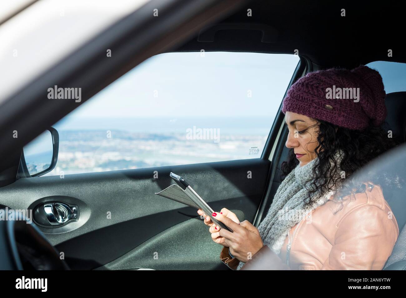 She is using a tablet while sitting in a car Stock Photo - Alamy