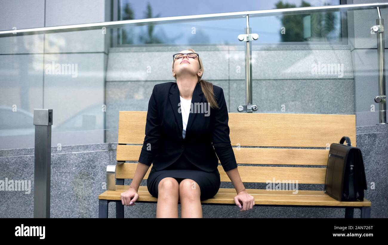 Tired but happy business woman sitting on bench, successful contract ...