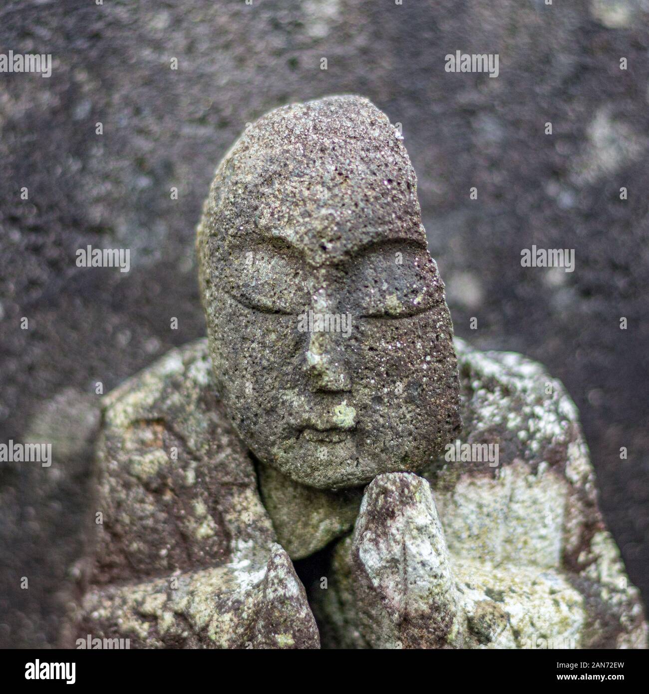 Ancient Buddhist stone relic with damaged head, covered with moss and ...