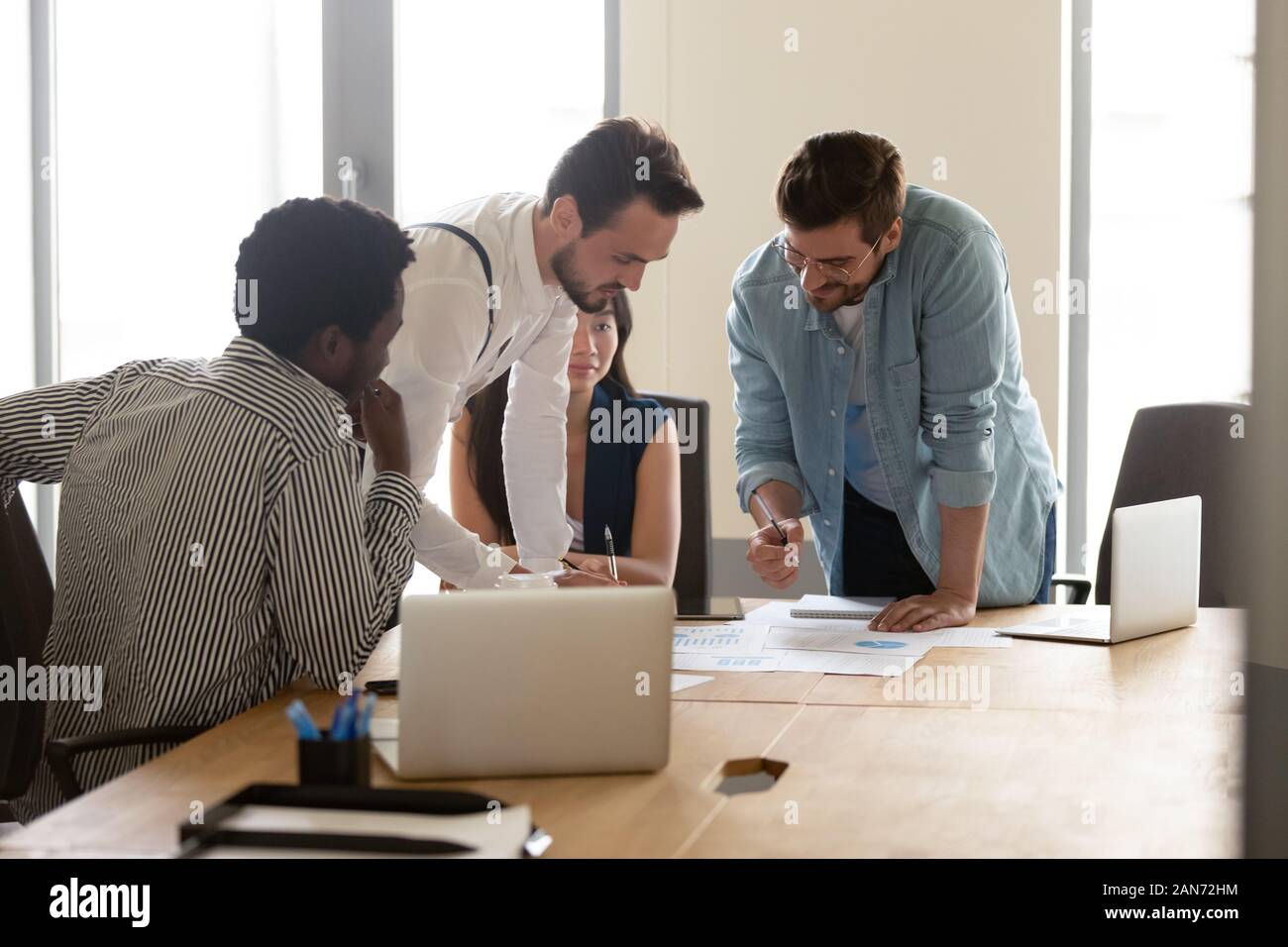 Multiracial colleagues brainstorm considering ideas at briefing Stock ...