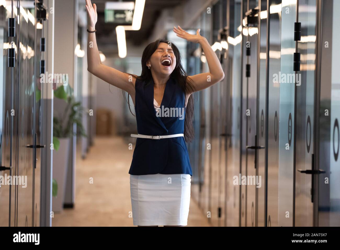 Excited young Asian female dance celebrate job success in hallway Stock ...