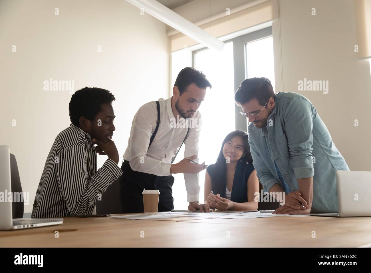 Multiracial employees talk brainstorming at team briefing in office ...