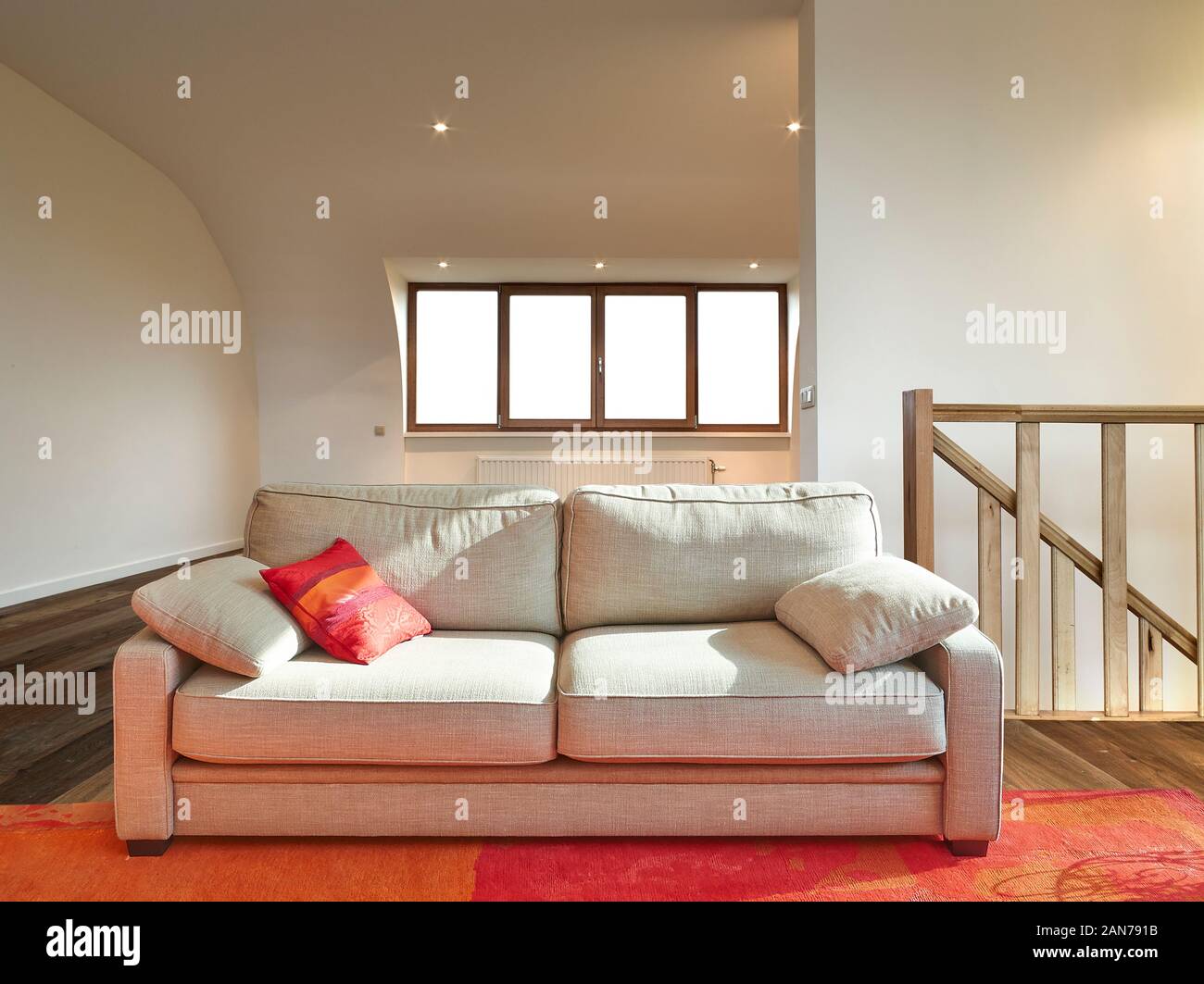 Modern interior with wooden floor and big sofa from front Stock Photo ...