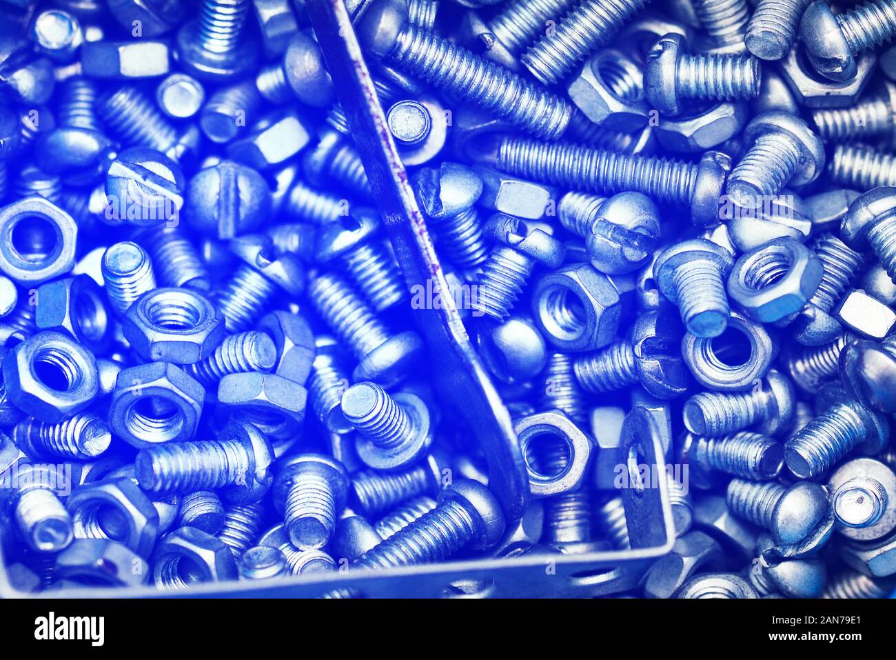 Nuts and bolts with blue tint. Metal parts for construction. Stainless ...