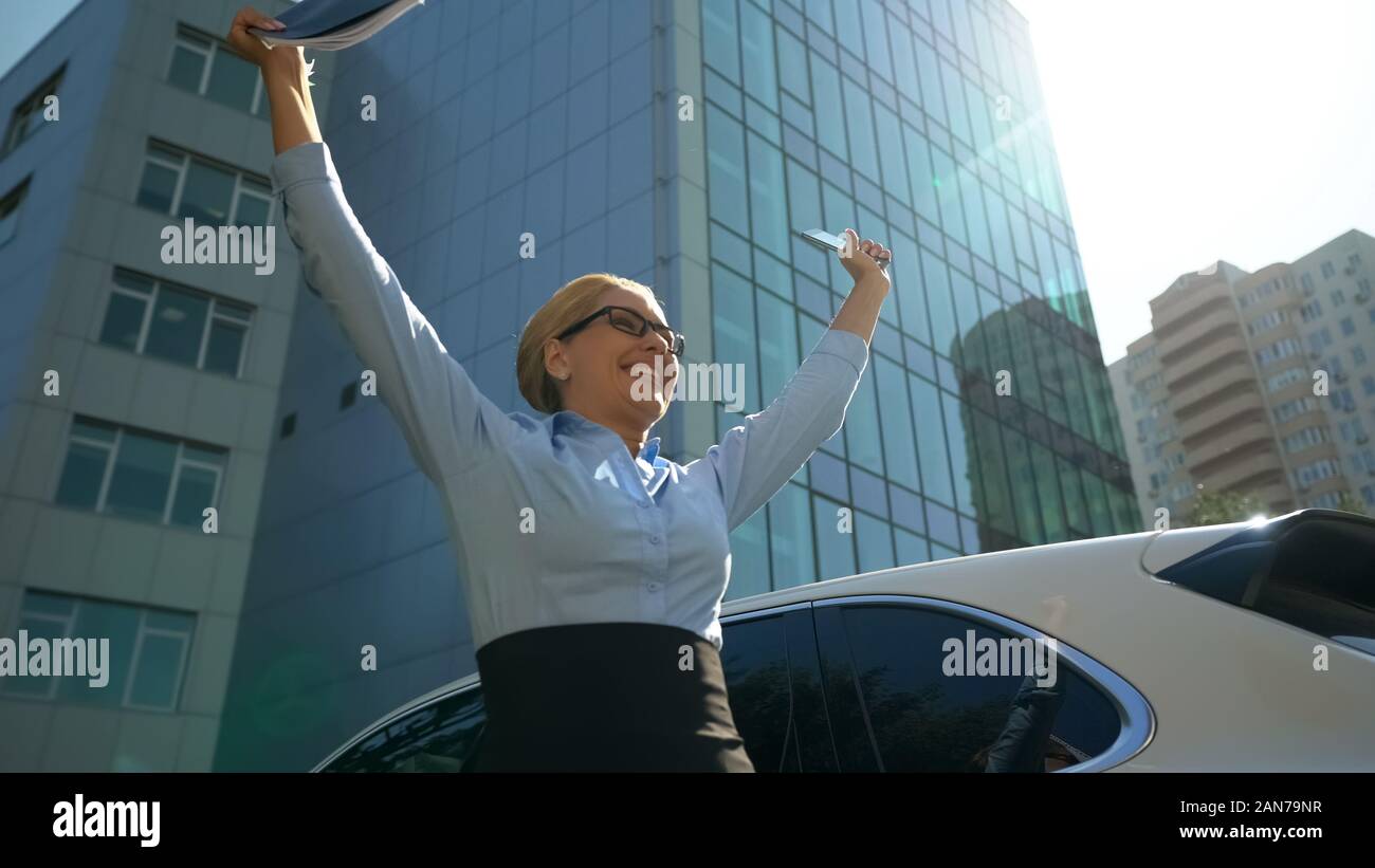 Extremely happy lady rising her hands up rejoicing to successful ...