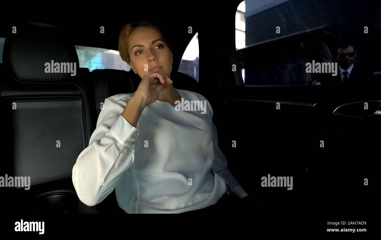 Busy lady sitting in car, planning future, personal assistant waiting ...