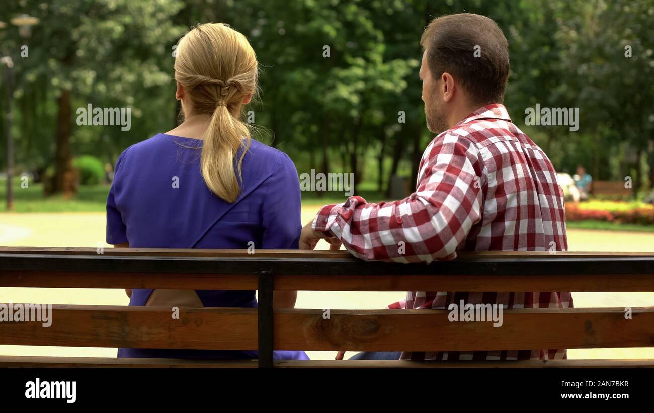 Indifferent man and woman sitting on bench, no common interests, break ...