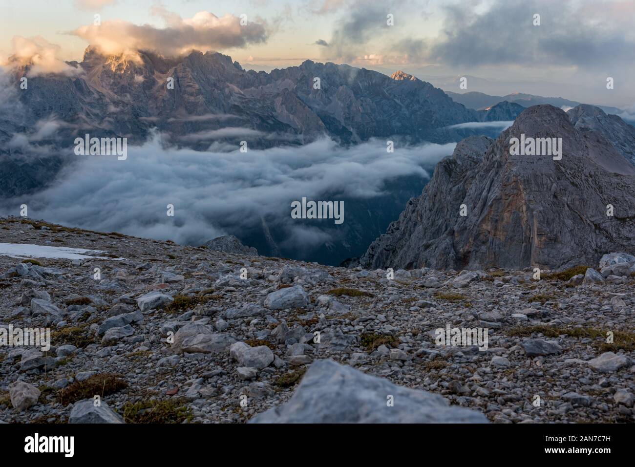 Spectacular mountain view with evening clouds rolling over peaks and ...