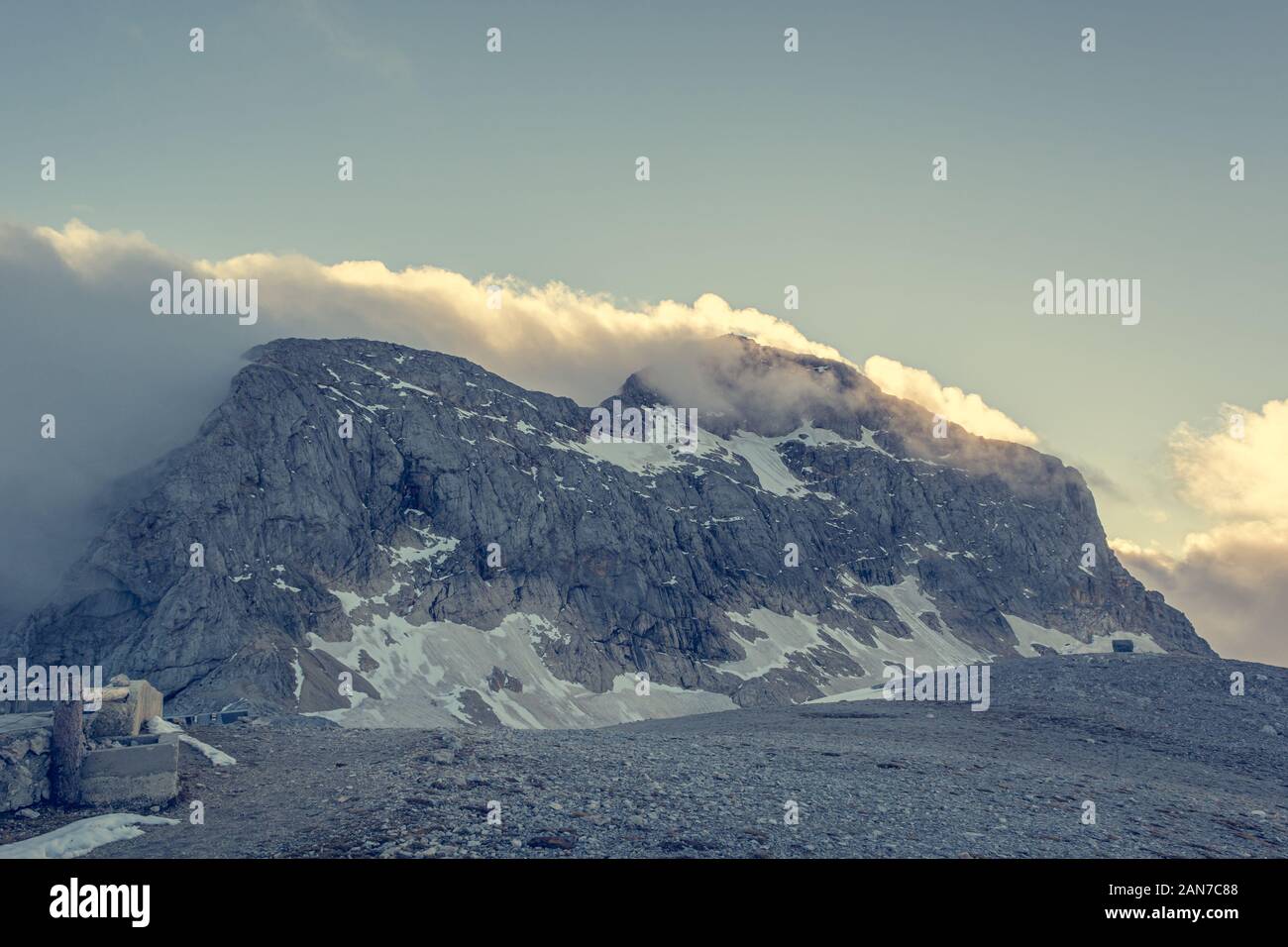Spectacular mountain view with evening clouds rolling over peaks and ...